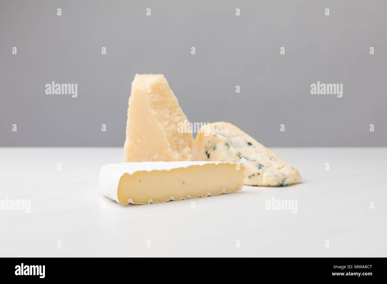 Close up view of brie, cheddar and blue cheese on gray Stock Photo - Alamy