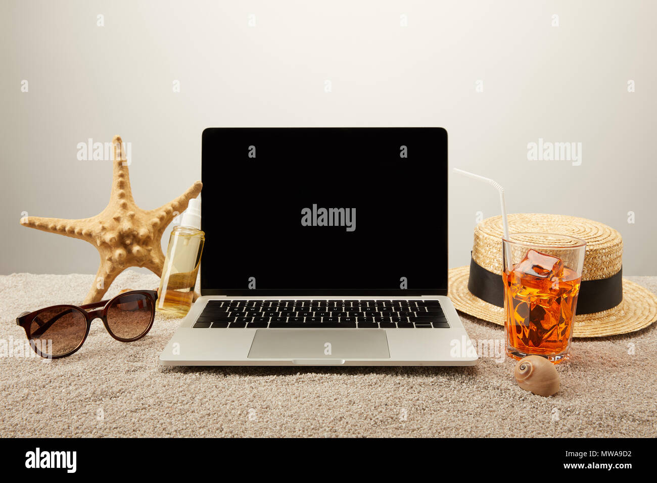 close up view of laptop with blank screen, refreshing cocktail and ...