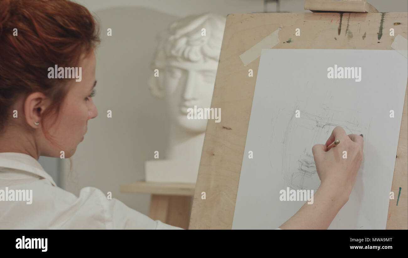 Concentrated woman artist painting plaster bust in art studio Stock ...