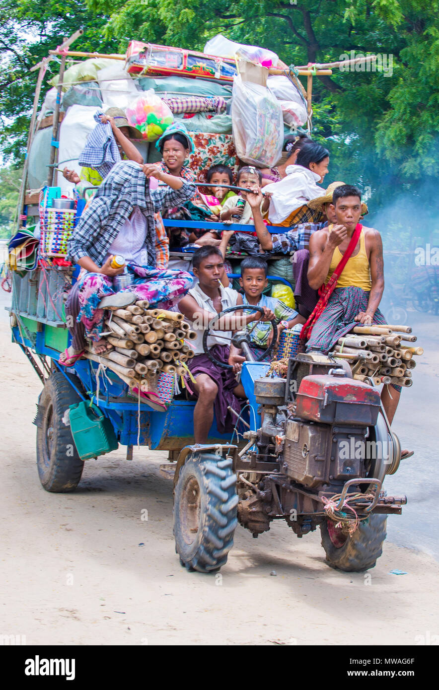Burmese farmers riding on an old tractor in a village in Shan state ...