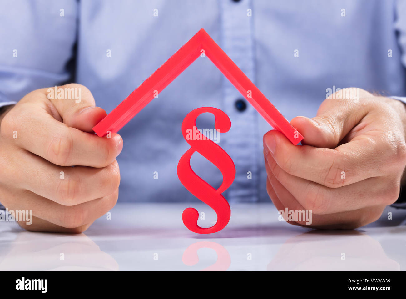 Human Hand Holding Roof Over Red Paragraph Symbol On Desk Stock Photo ...
