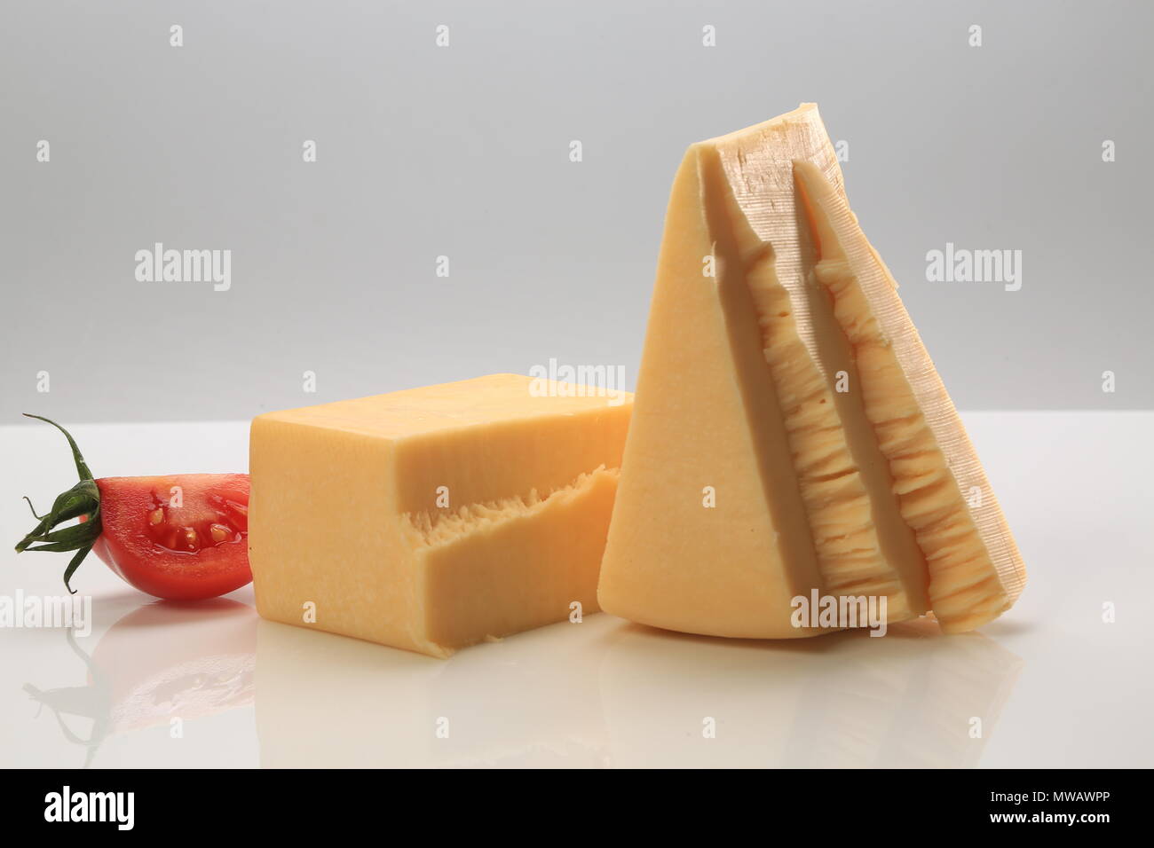 Block and triangle sliced cheese with a slice of tomato Stock Photo - Alamy