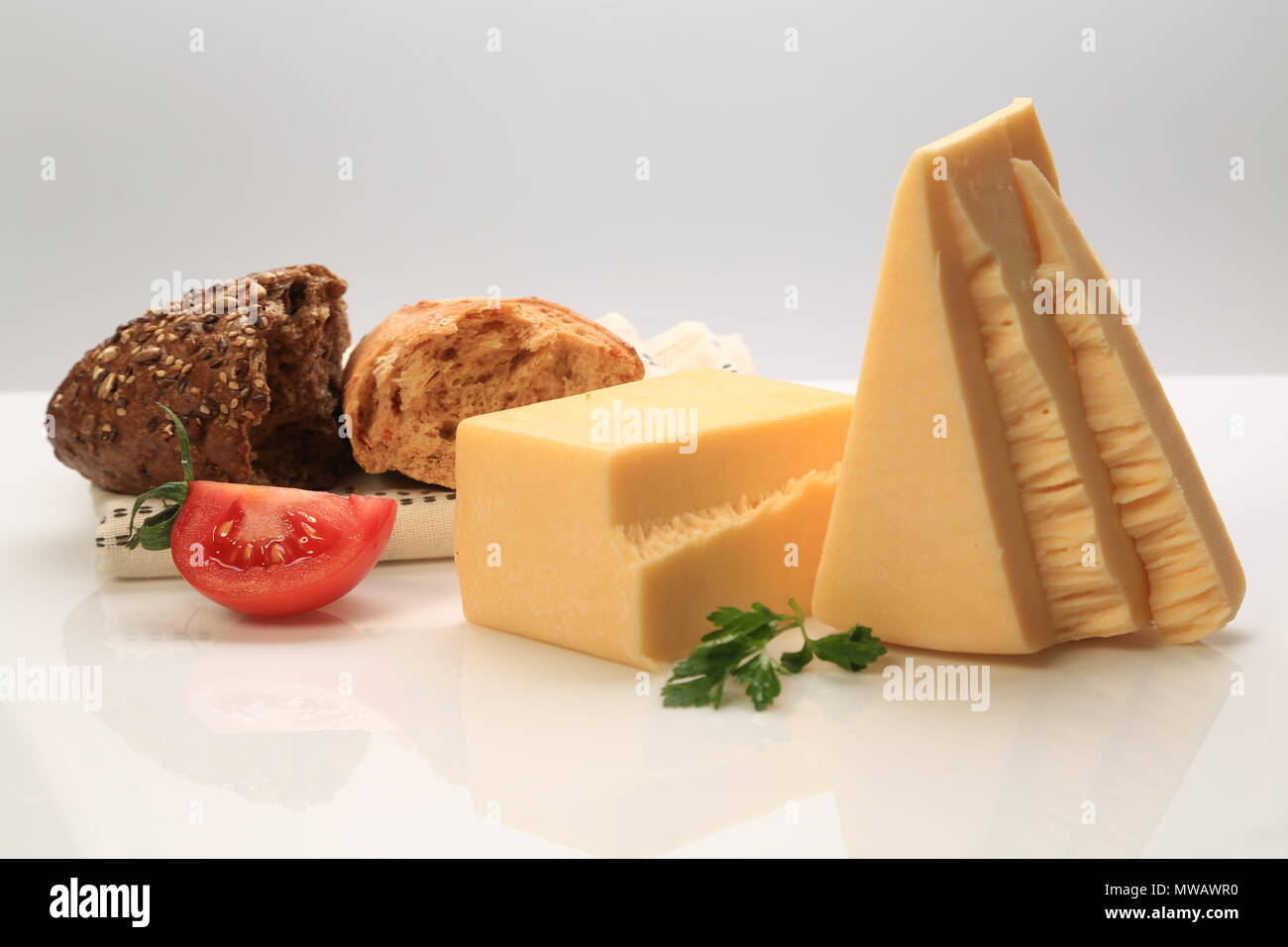 Block and triangle sliced cheese with a slice of tomato Stock Photo - Alamy