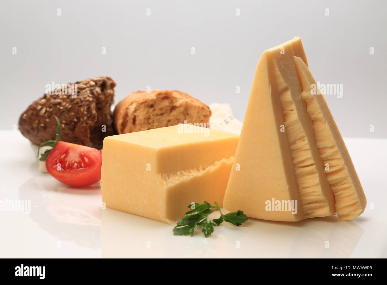 Block and triangle sliced cheese with a slice of tomato Stock Photo - Alamy