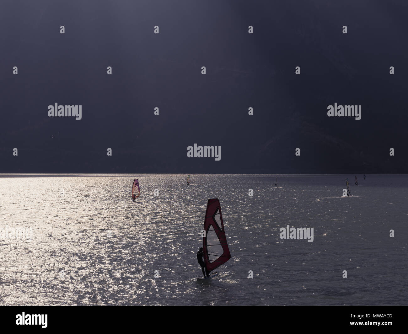 Lake with dramatic lighting and windsurfers, outdoors and nature ...