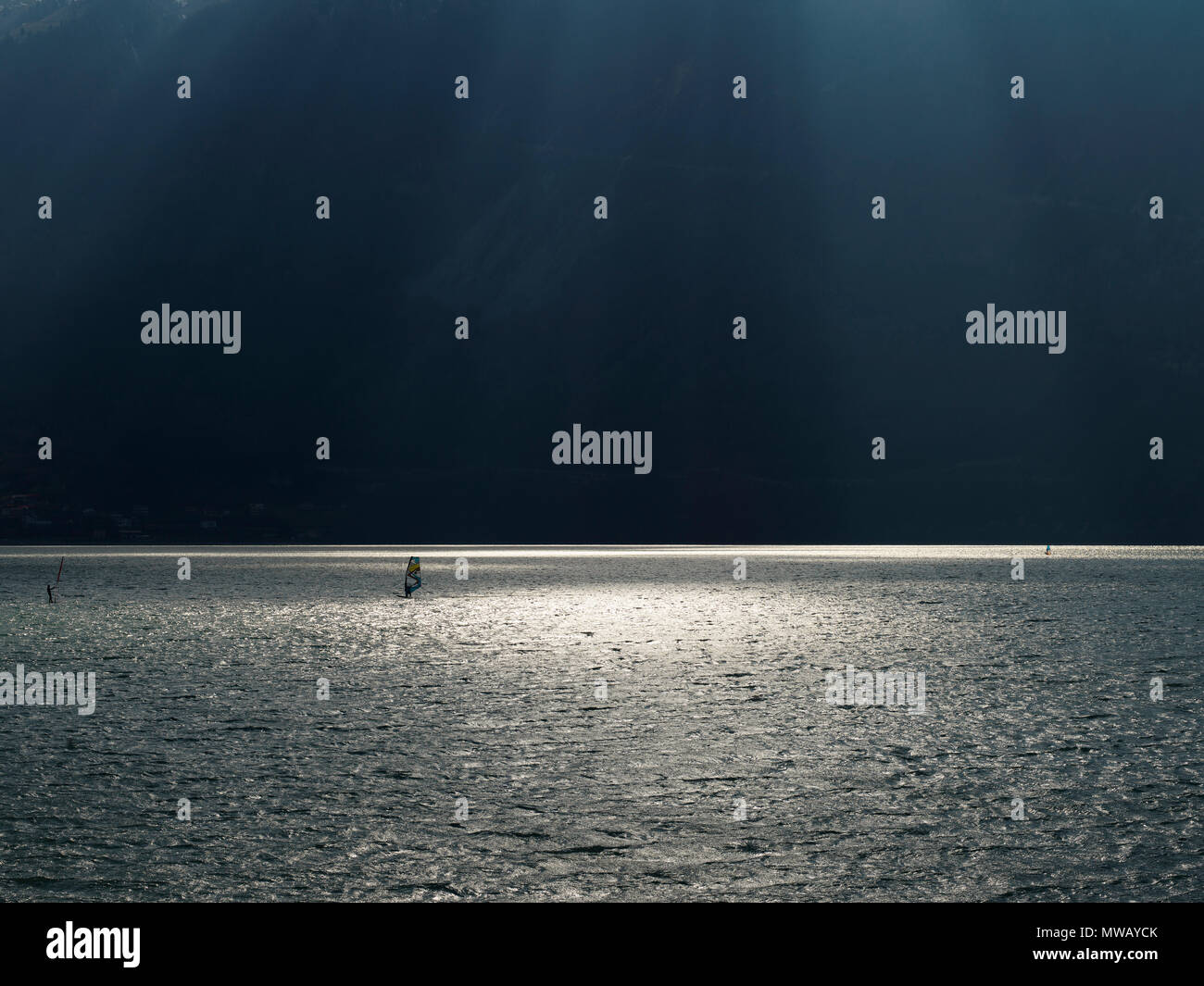 Lake with dramatic lighting and windsurfers, outdoors and nature ...