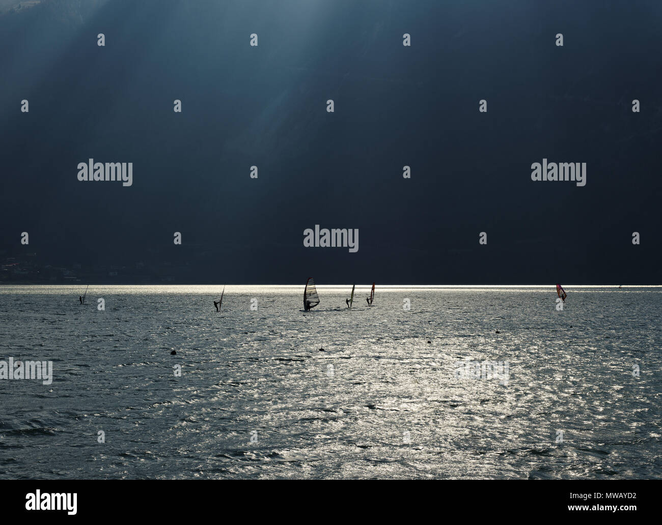 Lake with dramatic lighting and windsurfers, outdoors and nature ...