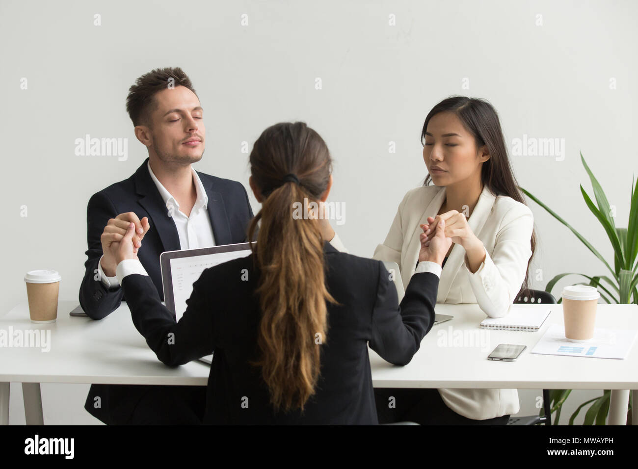 Mindful diverse team people holding hands meditating praying for Stock ...