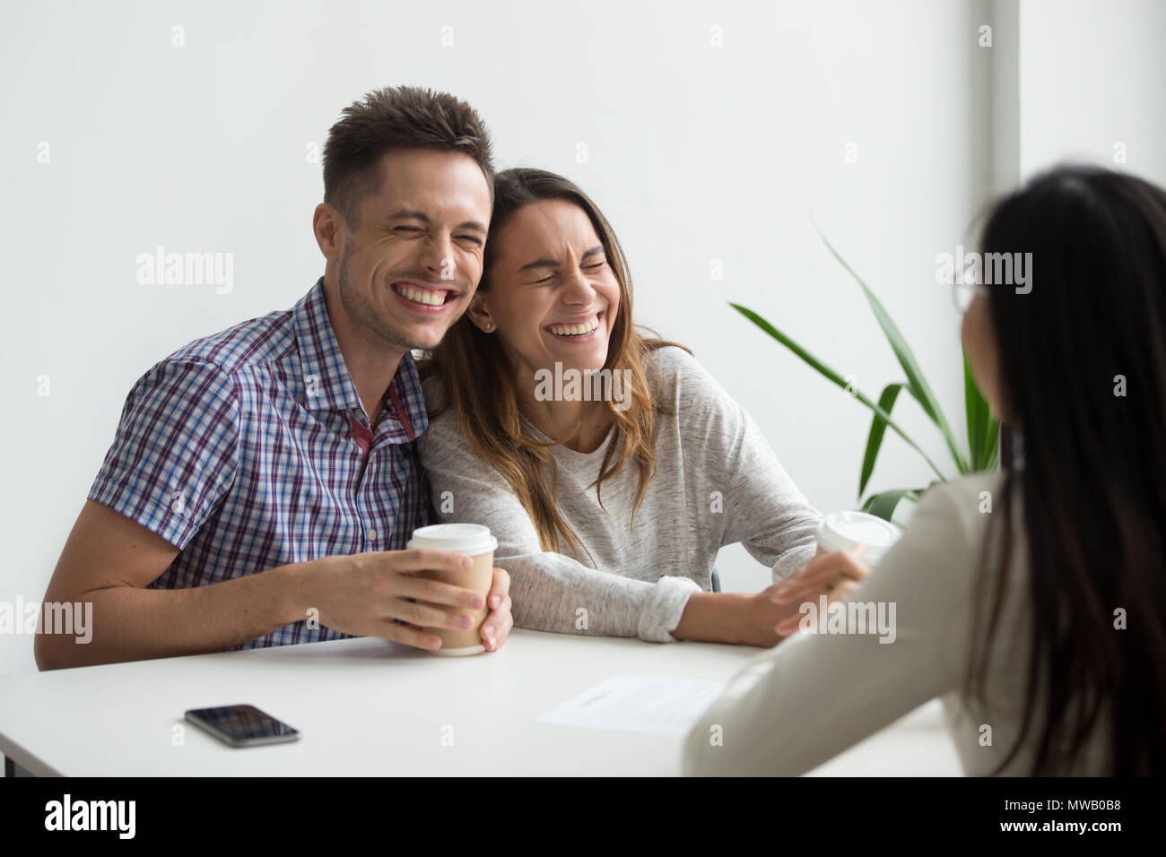 Happy couple clients laughing planning to sign contract at meeti Stock ...
