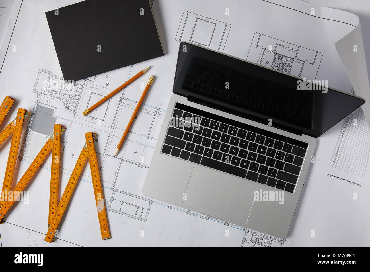 top view of laptop with blank screen, textbook, pencils and collapsible ...