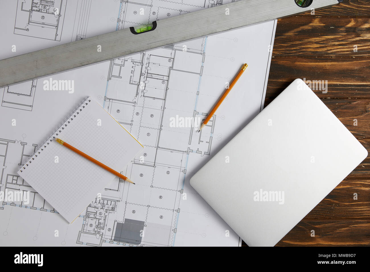 empty textbook, pencils, spirit level, notebook and blueprint on table ...