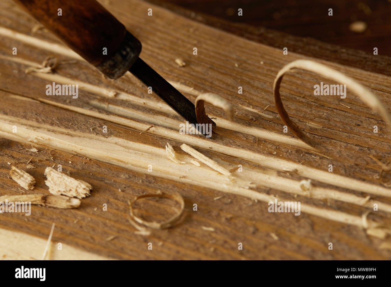 partial view of chisel sticking in wooden plank with scobs Stock Photo ...