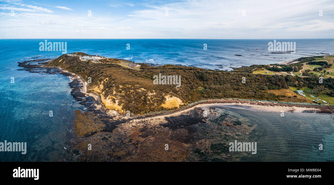 Aerial panorama of rocky outcrop extending into shallow ocean water in ...
