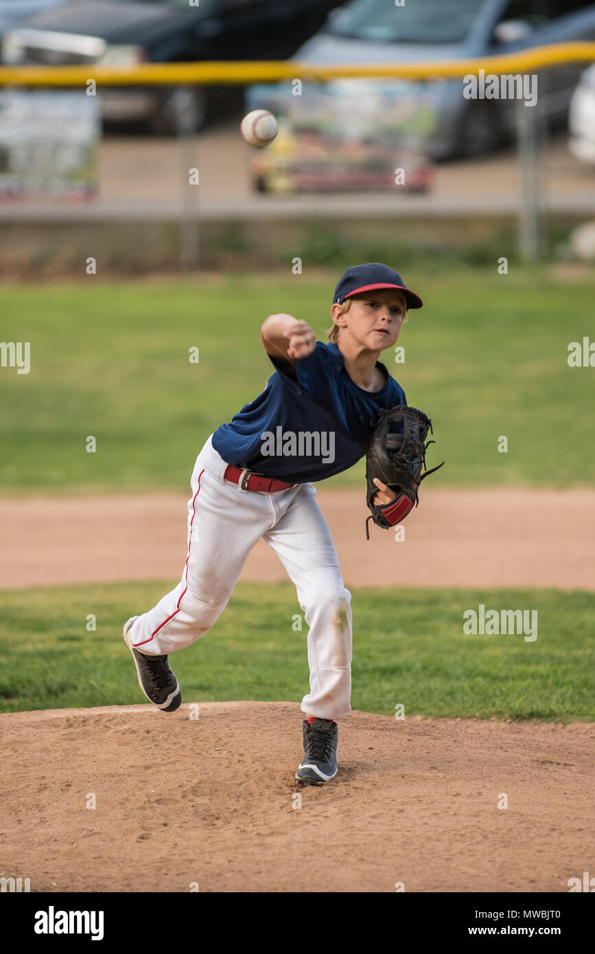 Youth baseball pitcher releases ball with look of expecting a strike ...