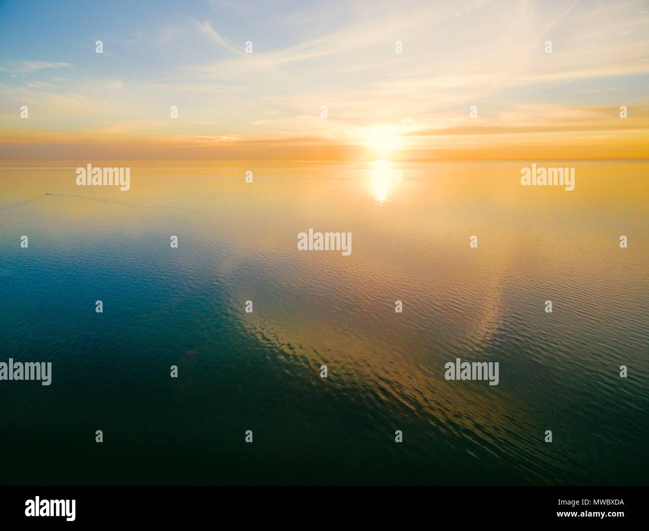 Nothing but sun and calm ocean water at sunset Stock Photo - Alamy