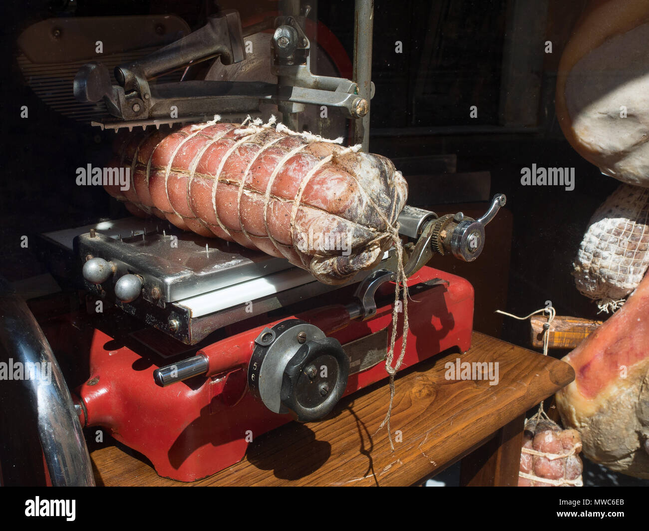 vintage red ham slicer with big sausage in a traditional italian food ...
