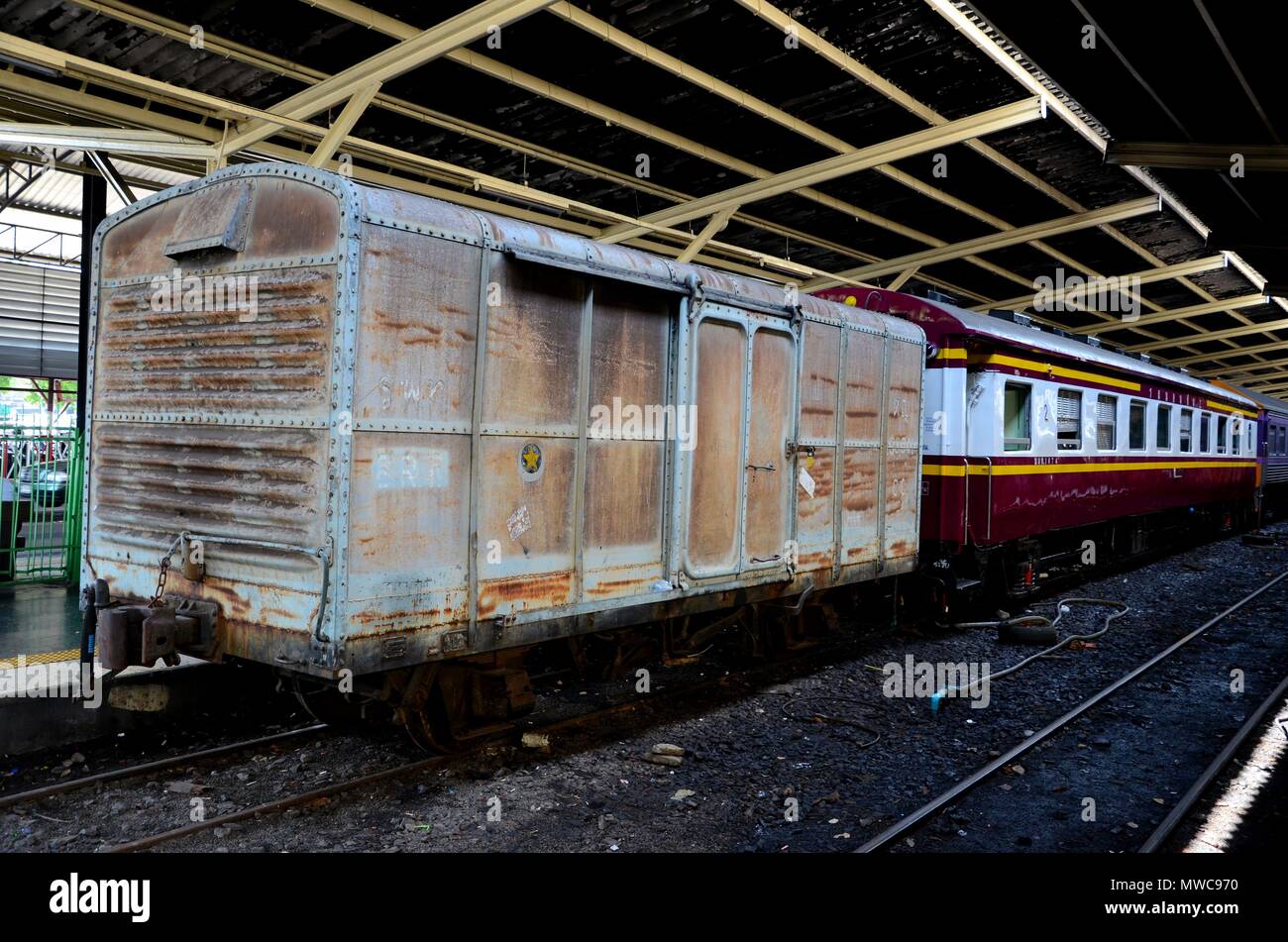 Old weathered Thai rail boxcar and passenger railway carriage parked at ...