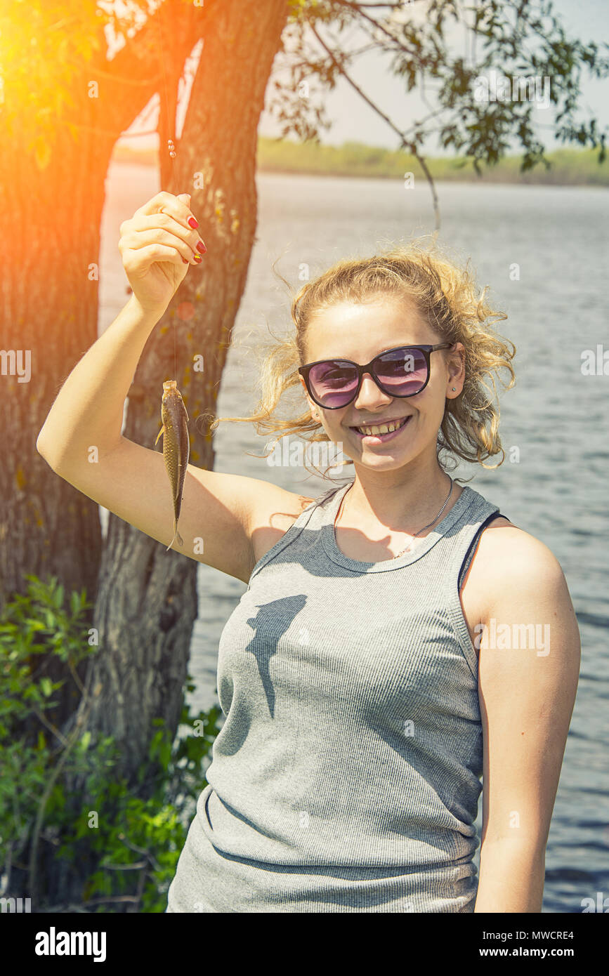 girl holding a fish caught in her hand ,rejoicing and smiling Stock ...