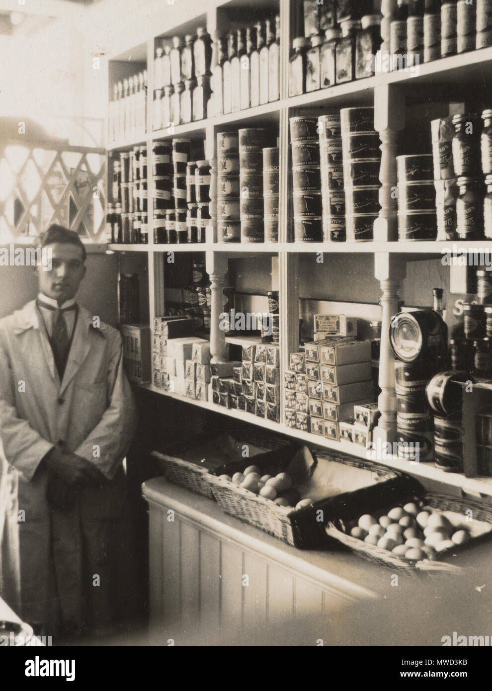 Grocery shop interior around 1910, with male shop assistant. Shelves ...