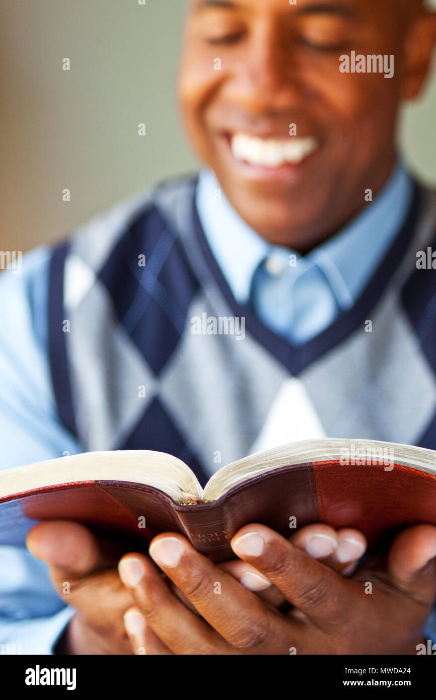 African American man sitting on a sofa reading Stock Photo - Alamy