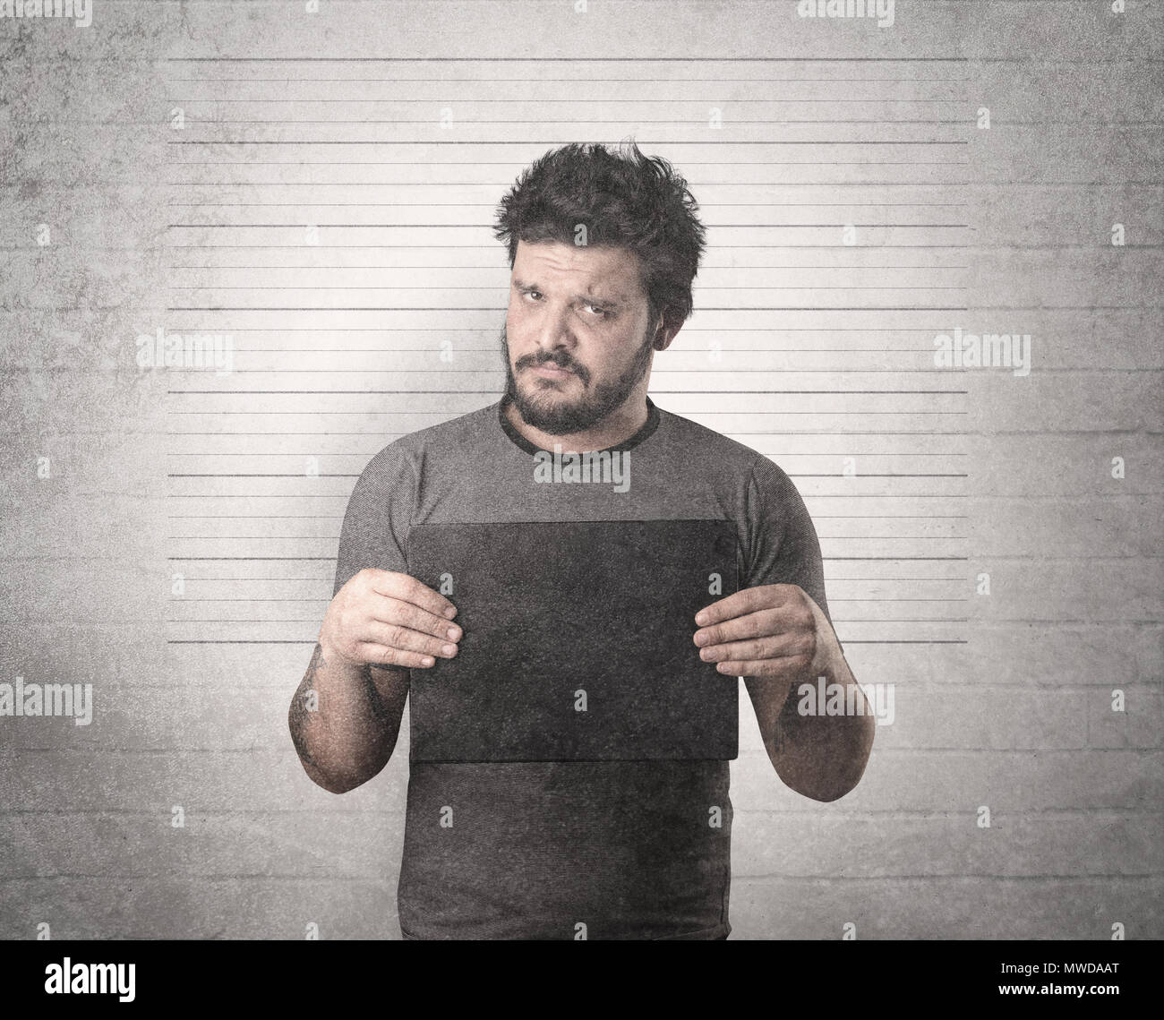 Gangster in front of a wall with table on his hand Stock Photo - Alamy
