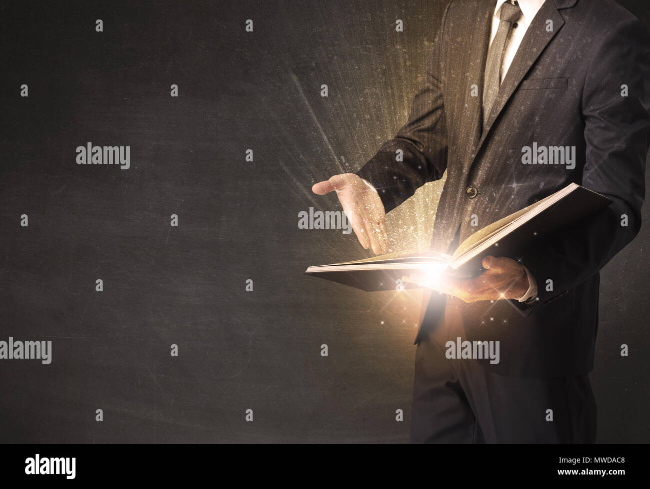 Man holding and reading a shiny book Stock Photo - Alamy