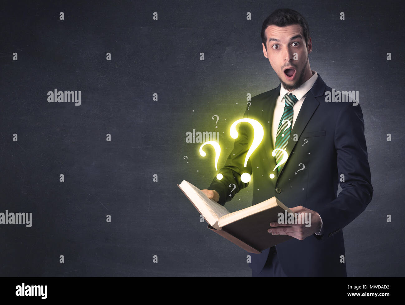 Businessman holding a book with question mark symbol Stock Photo - Alamy