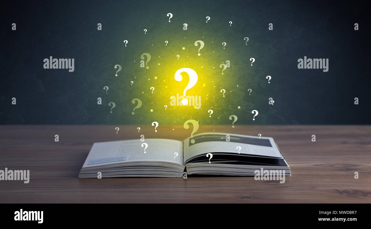 Yellow question marks hovering over open book Stock Photo - Alamy