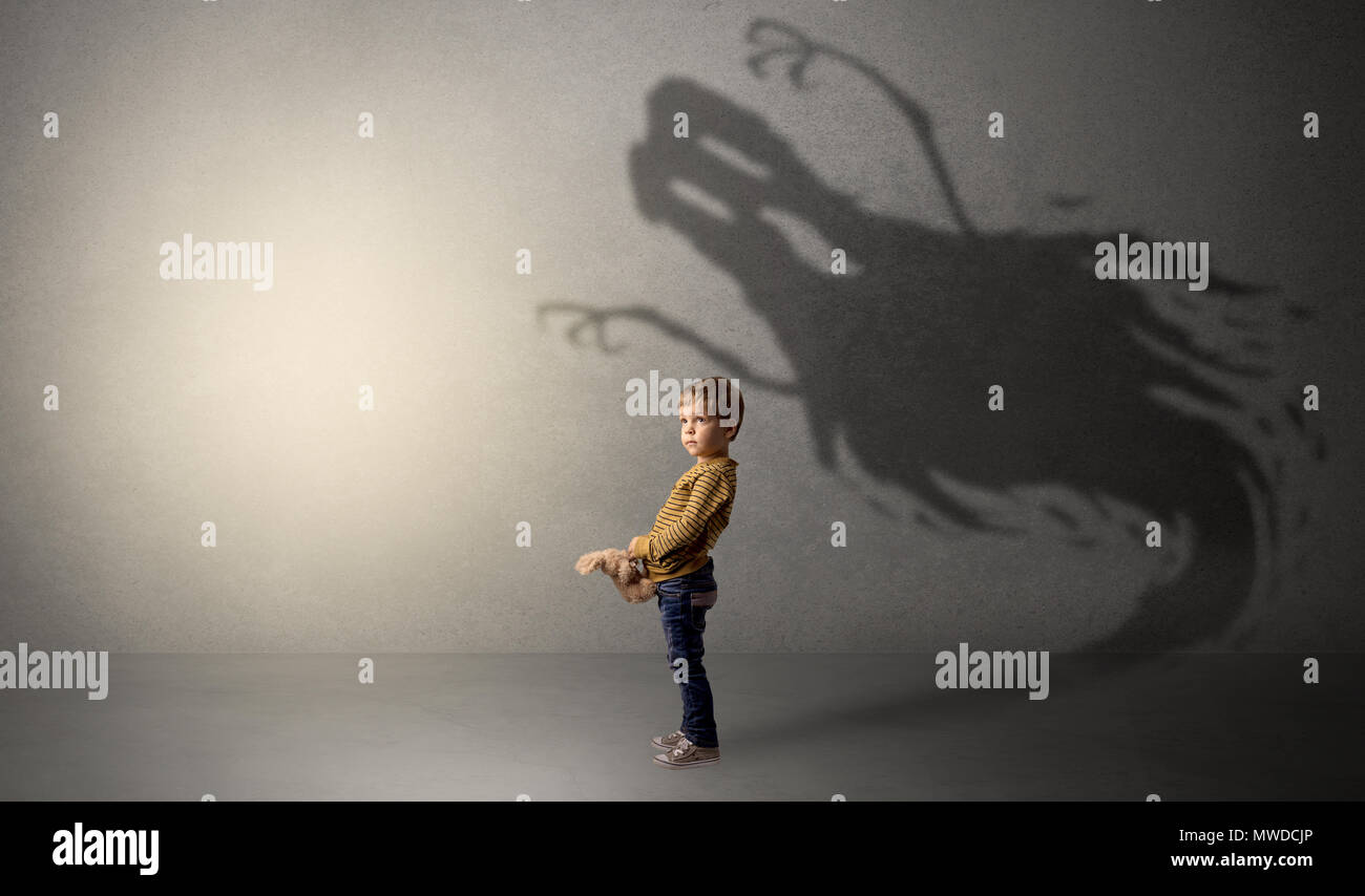 Scary ghost shadow in a dark empty room with a cute blond child Stock ...