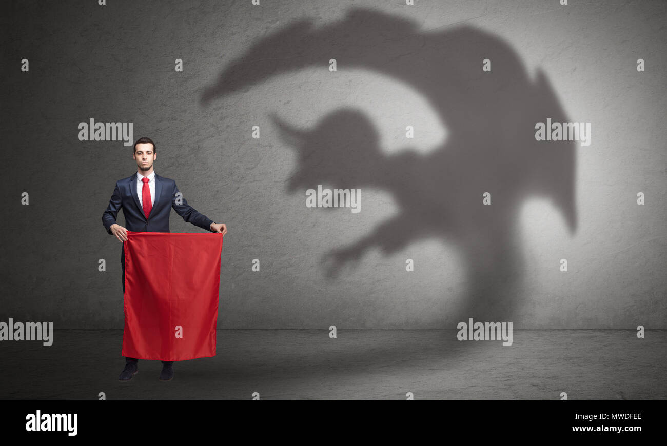 Businessman standing with red cloth in his hand and imp shadow on the ...