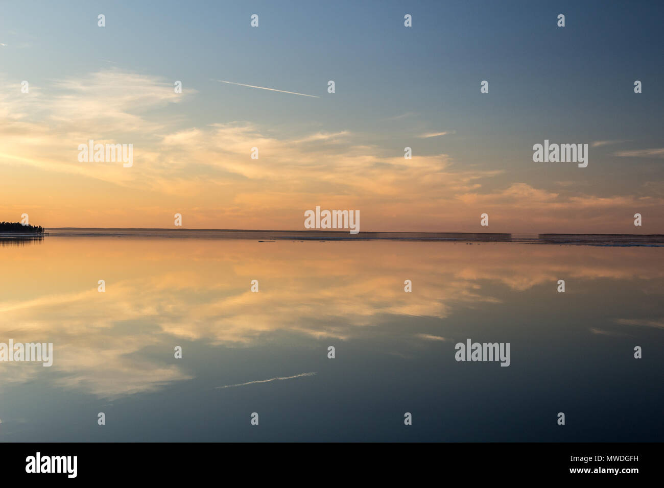 Sea surface with reflection of sky and clouds at sunset Stock Photo - Alamy