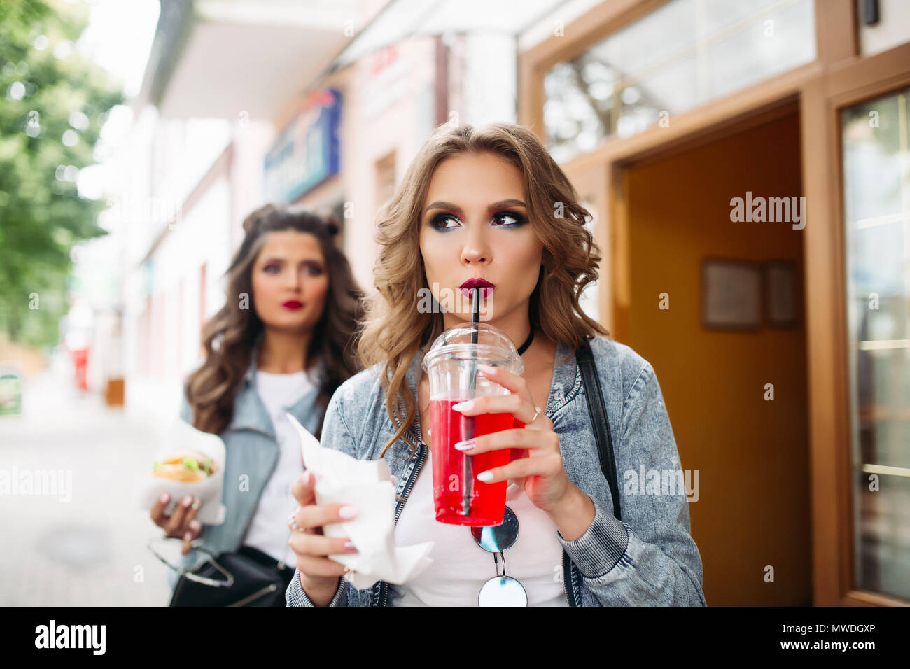 Beautiful girls with make up and hairstyle drinking fizzy drink and ...