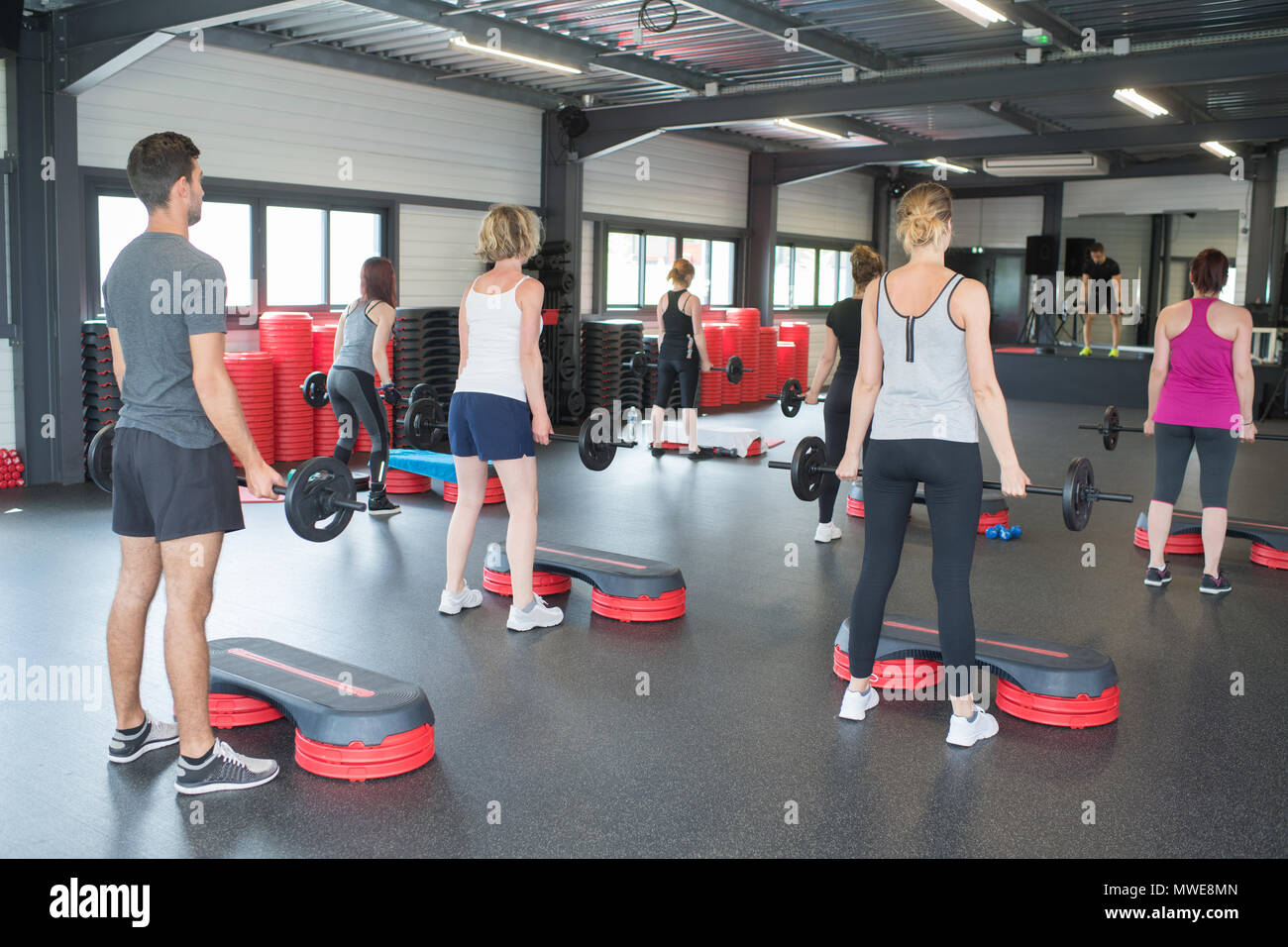 people exercising in gym doing squats working out with barbells Stock ...