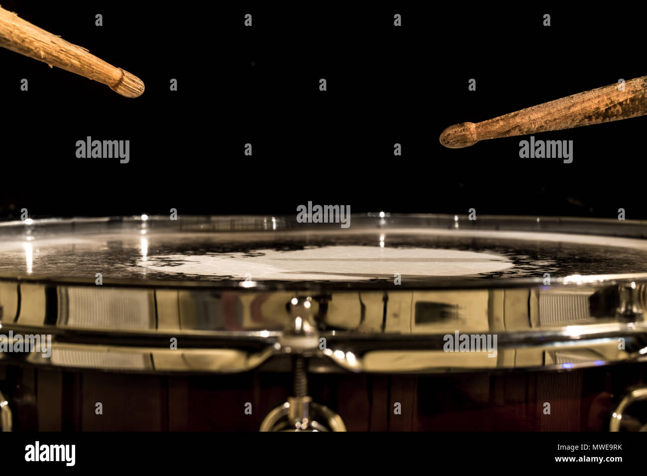 working drum with drum sticks, musical instrument on black background ...