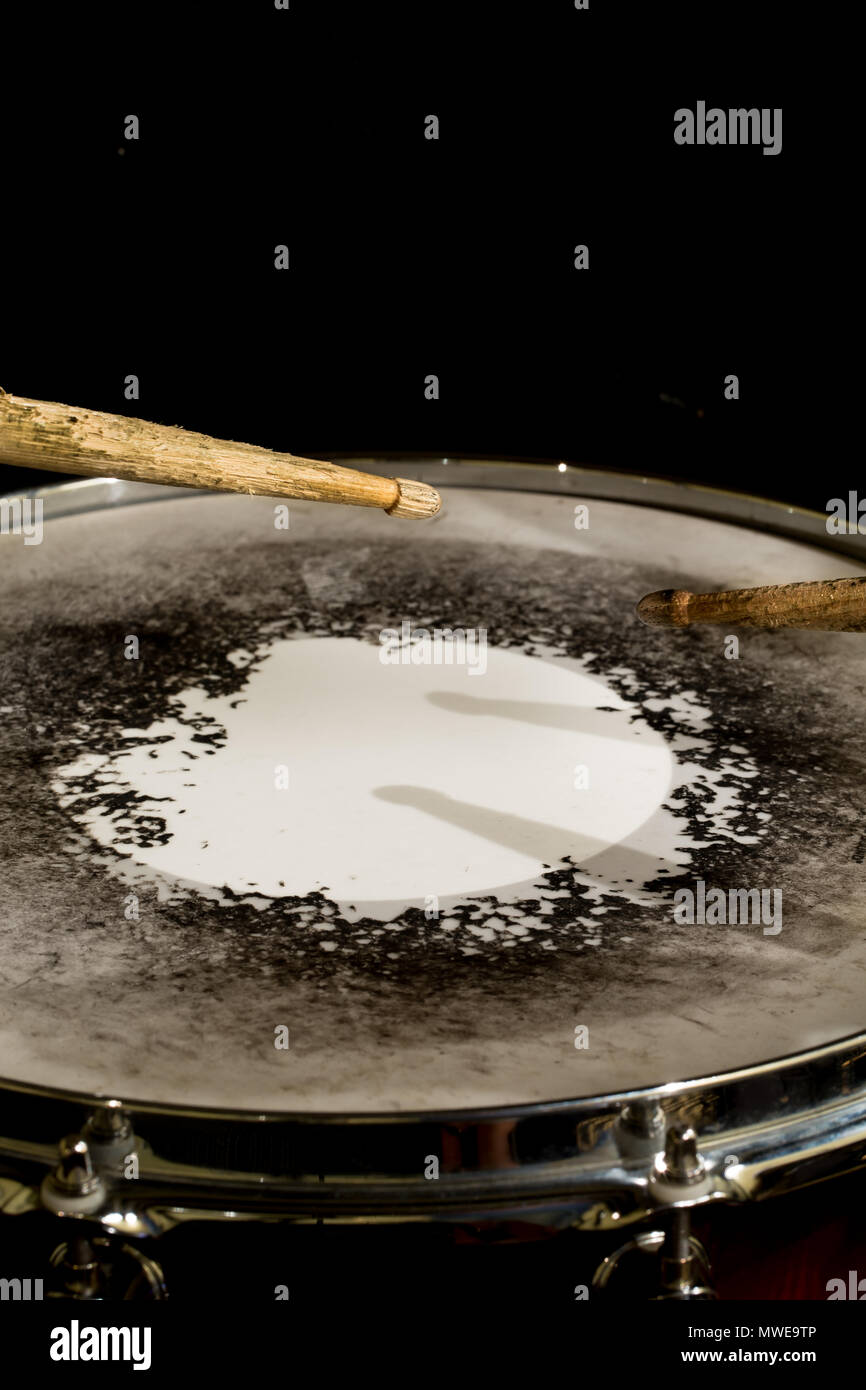 working drum with drum sticks, musical instrument on black background ...