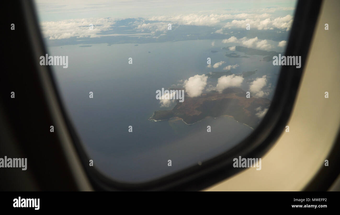 View through an airplane window on the tropical island, ocean, sea, sky ...