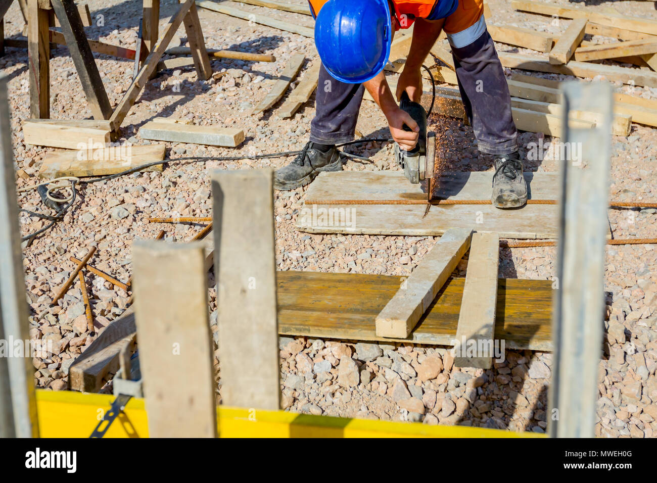 Worker is using abrasive grinding machine to set up armature to right ...