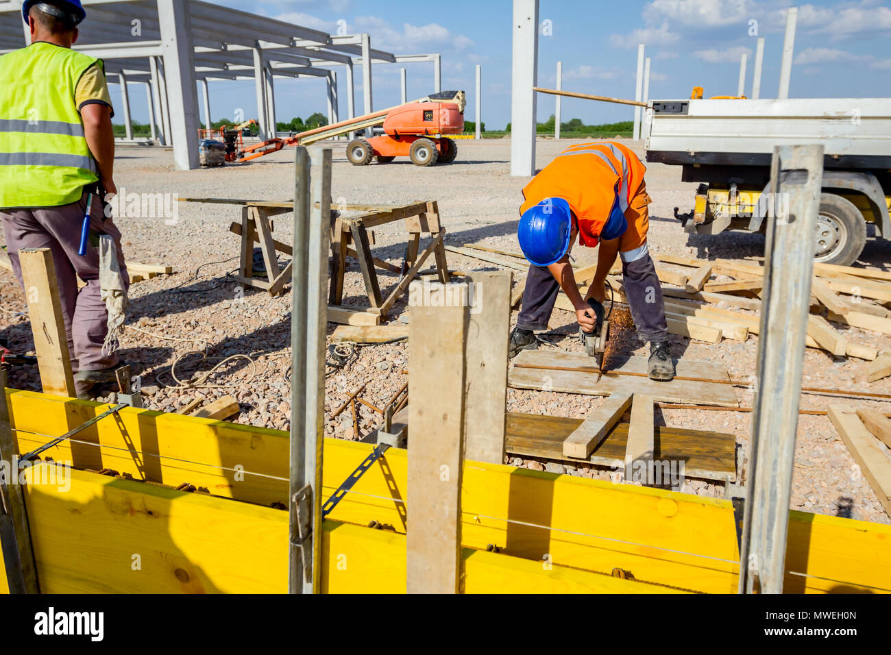 Worker is using abrasive grinding machine to set up armature to right ...