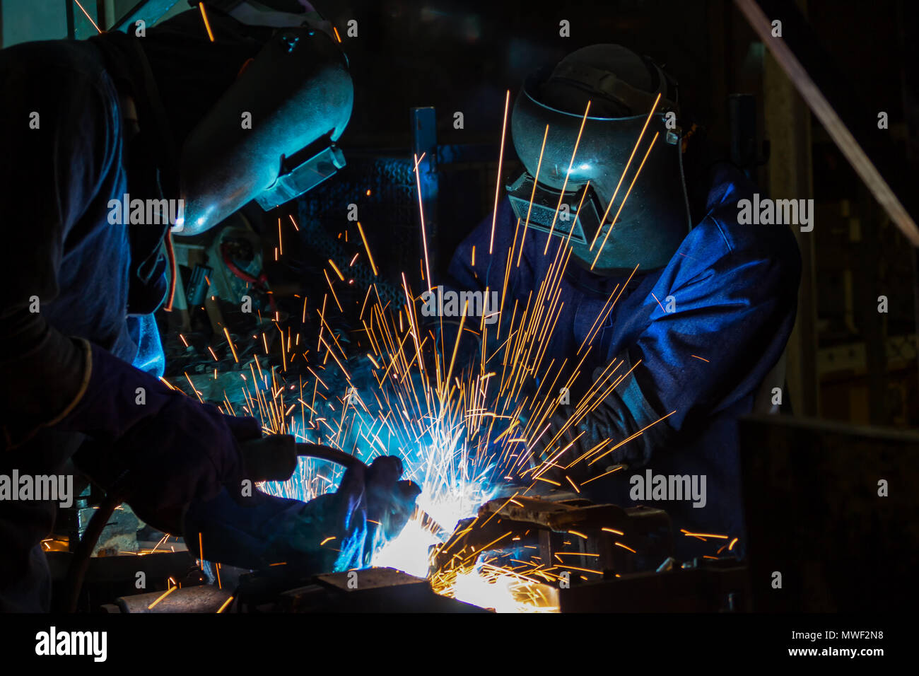 Team welder are welding metal part in factory Stock Photo - Alamy