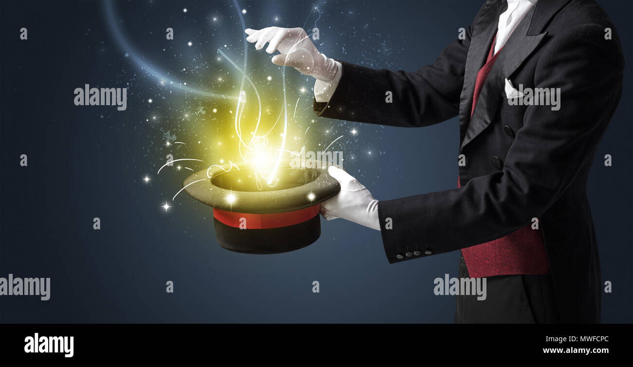 Magician hand conjure with wand light from a black cylinder Stock Photo ...