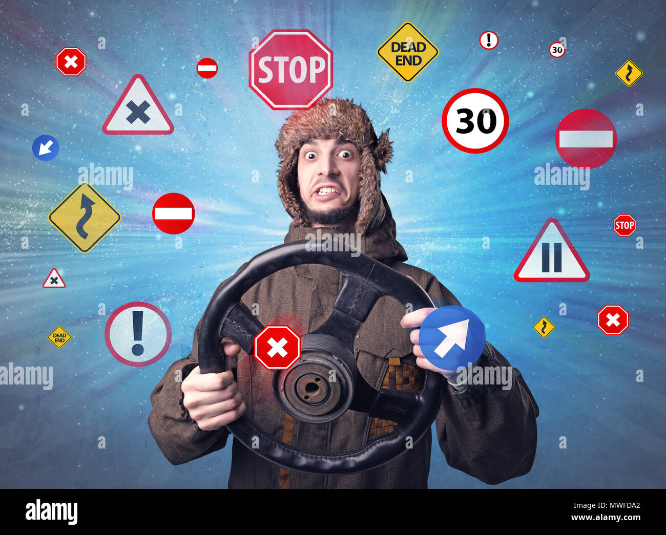 Young man holding black steering wheel with road signs surrounding him ...