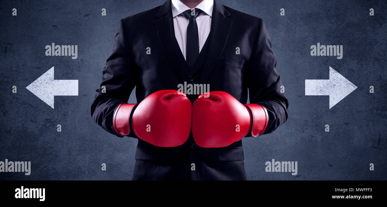 A confident businessman standing with red boxing gloves on his hand in ...