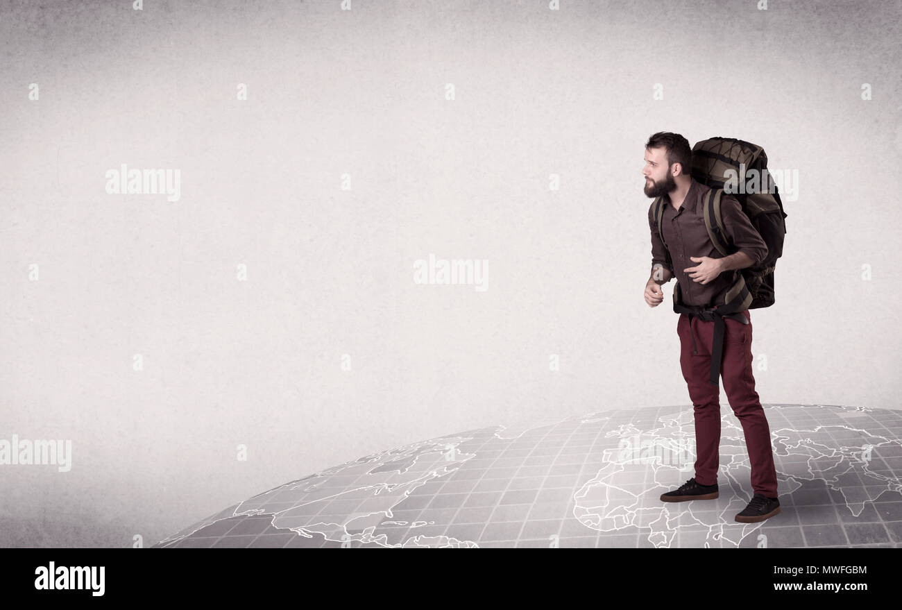 Handsome young man with a backpack on his back standing on a world map ...