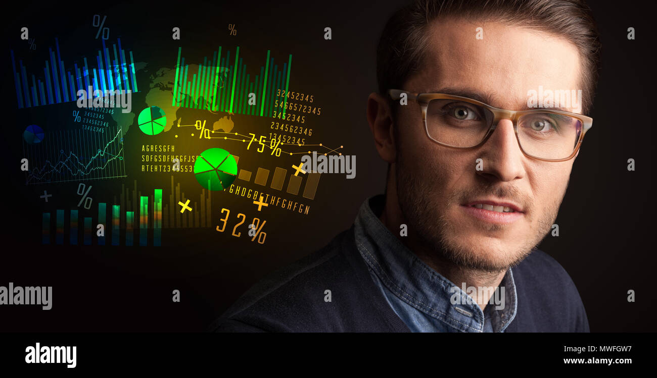 Portrait of a young businessman with colorful charts and graphs next to ...
