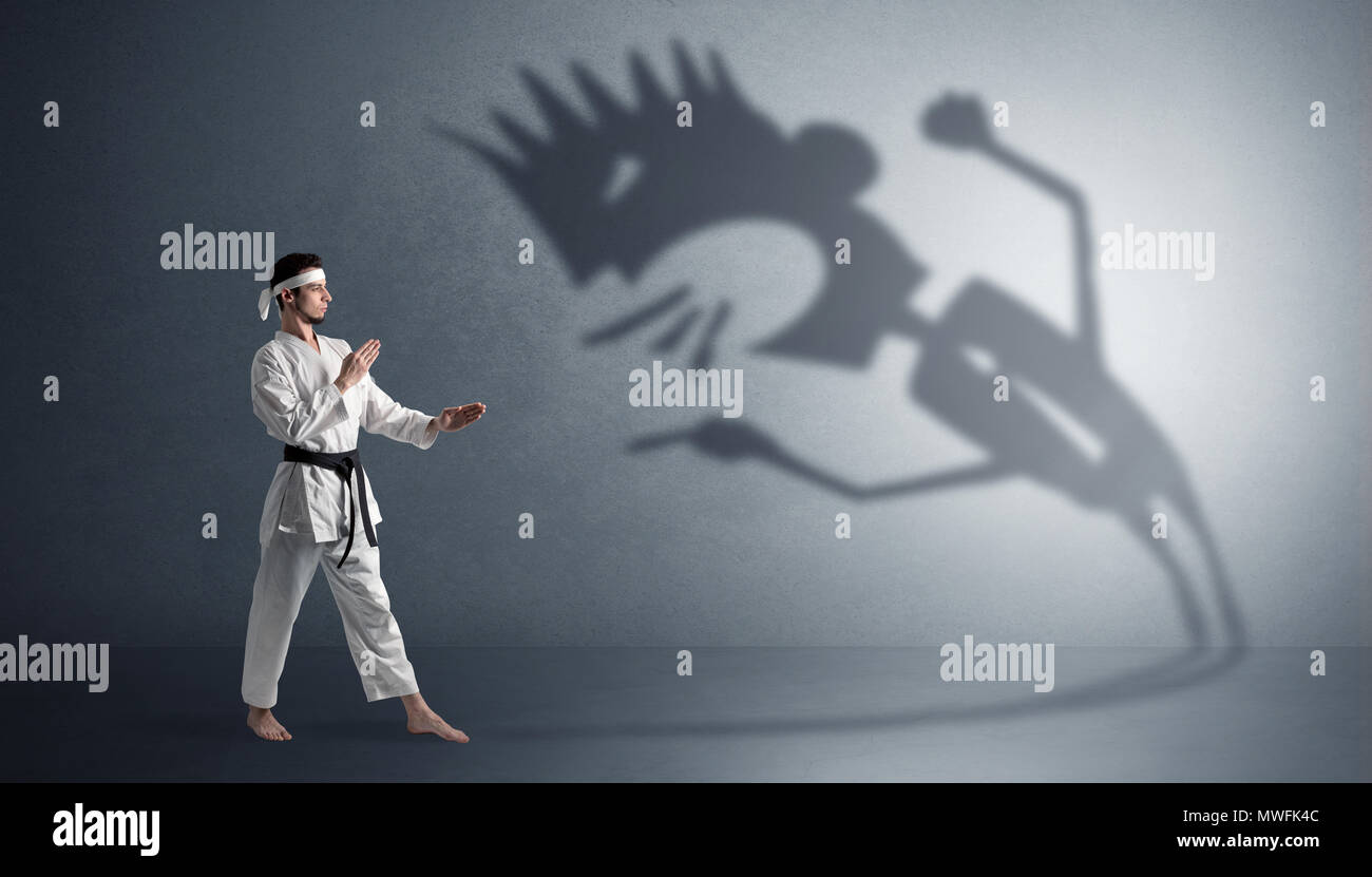 Young karate man fighting with a big black scary shadow Stock Photo - Alamy