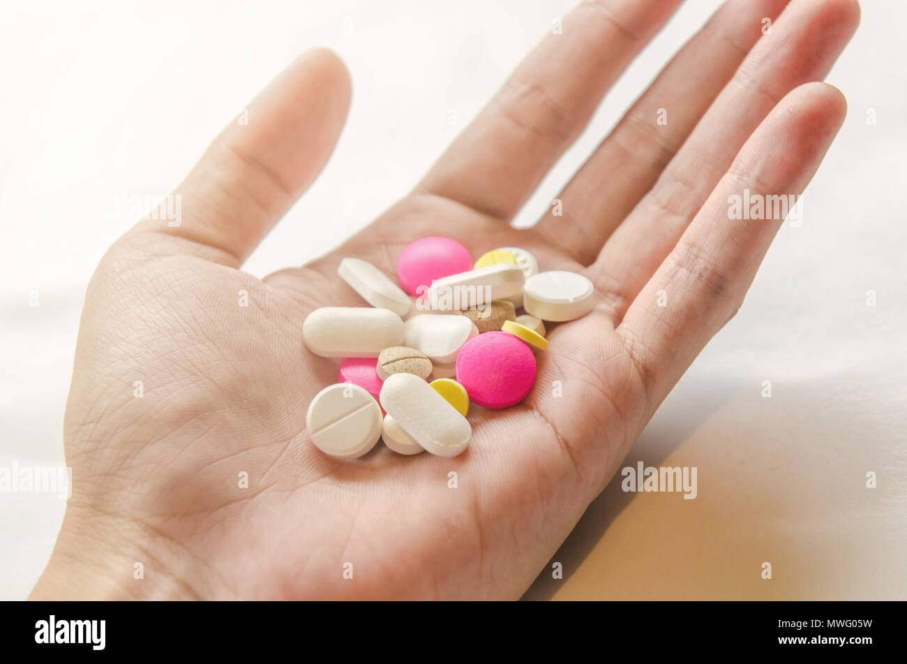 Close-up of the pills on the hand and white background, A hand hold the ...