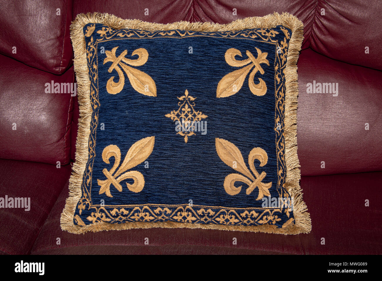 medieval fabric coushion on red leather couch Stock Photo - Alamy