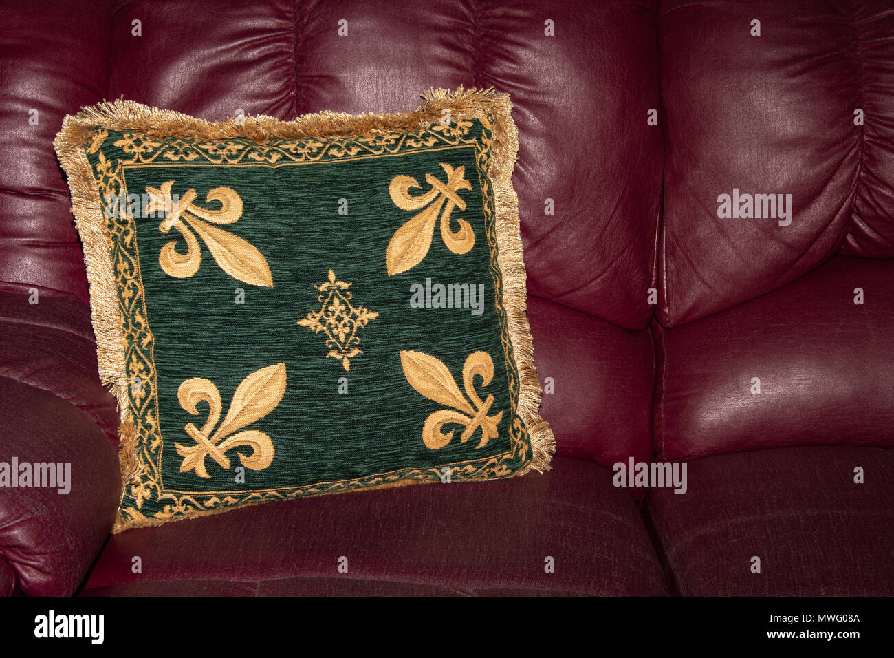 medieval fabric coushion on red leather couch Stock Photo - Alamy