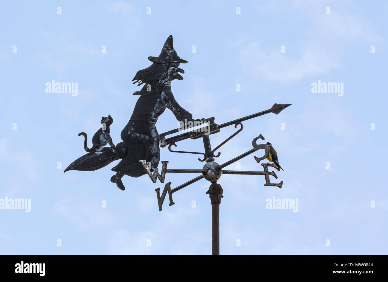Witch and cat weather vane on the roof of a house. Witch weathervane ...