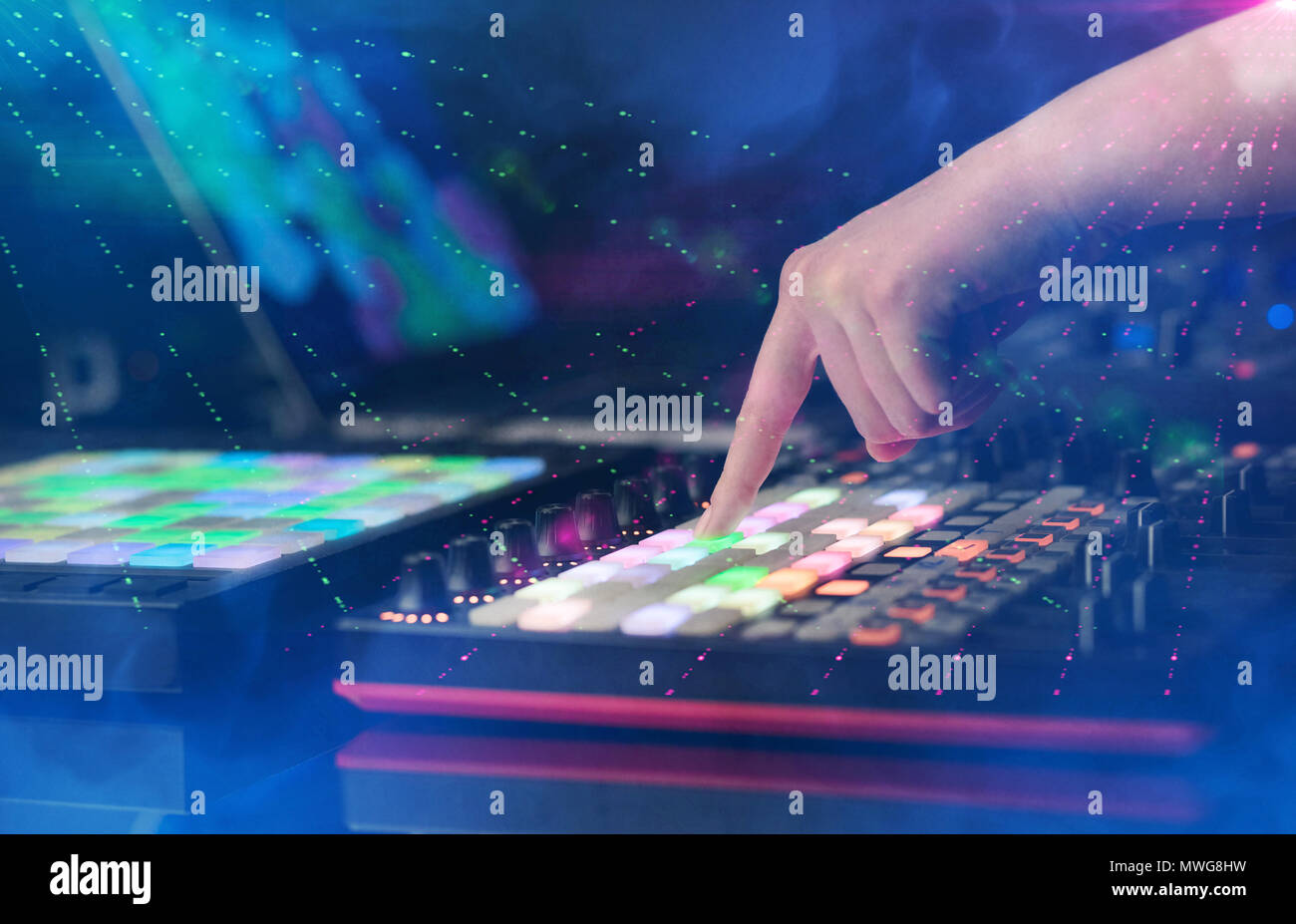 Hand mixing music on midi controller with party club colors around ...